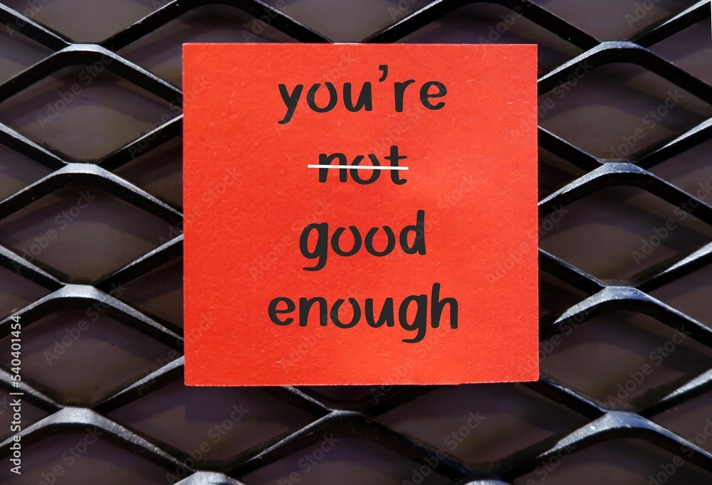 Red note paper with handwritten text YOU'RE NOT GOOD ENOUGH, crossed ...