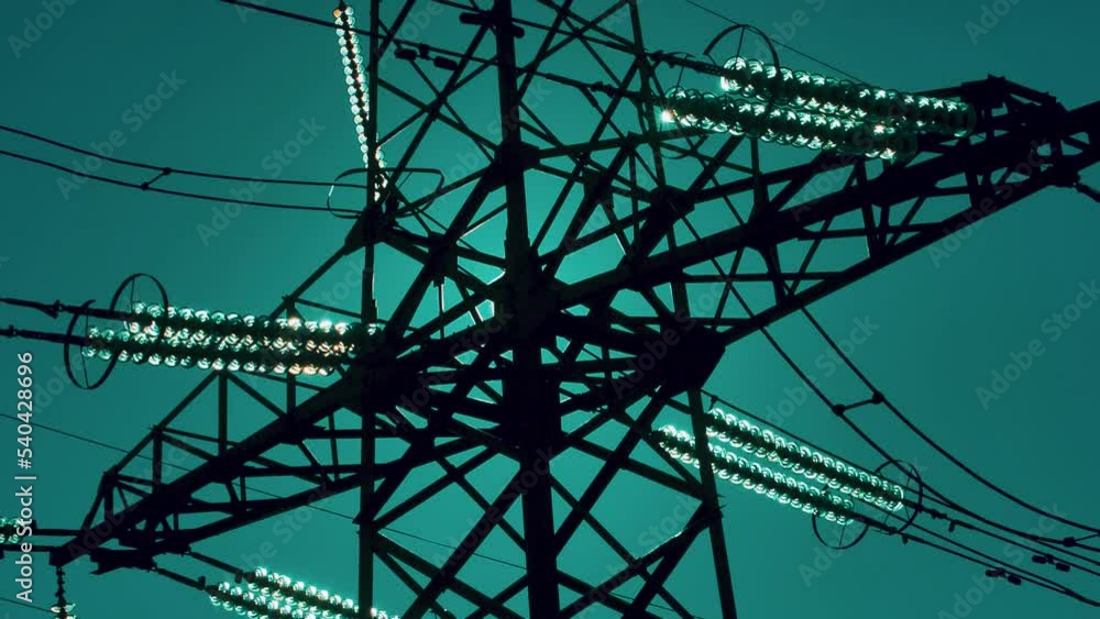Power lines with sun rays on blue sky. High voltage substation ...