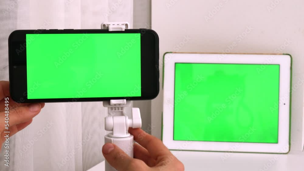 White horizontal tablet and black smartphone device with green screen ...