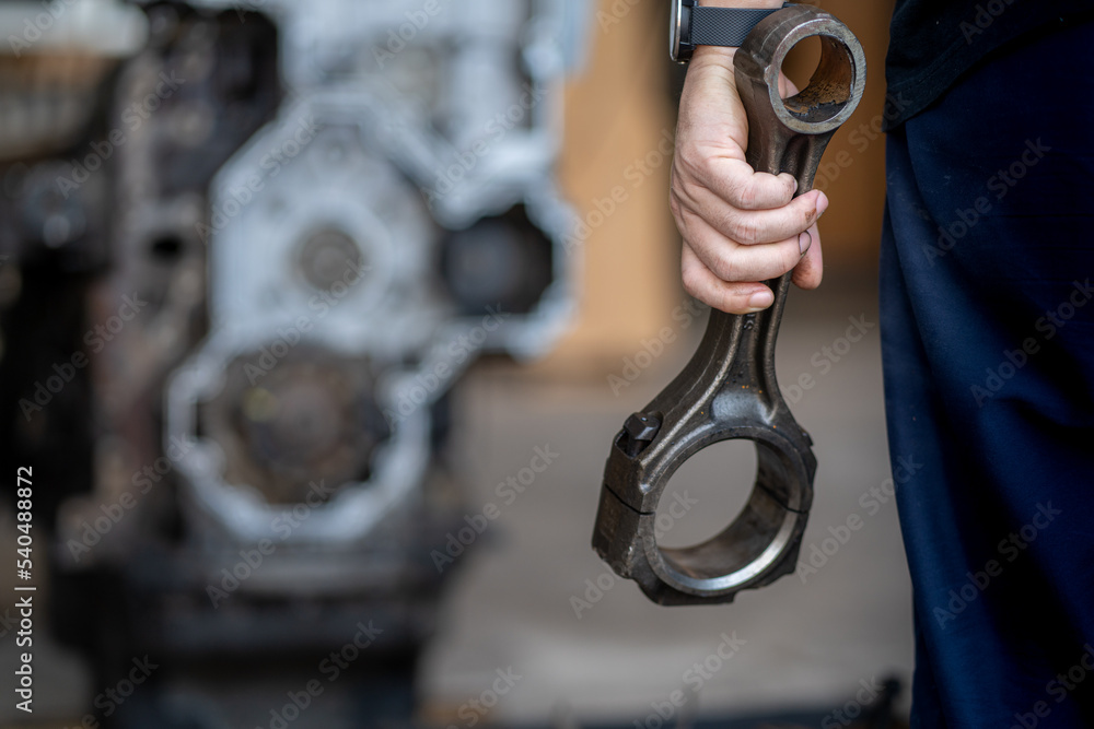 Mechanic man holding piston rod of diesel commonrail engine in heavy ...