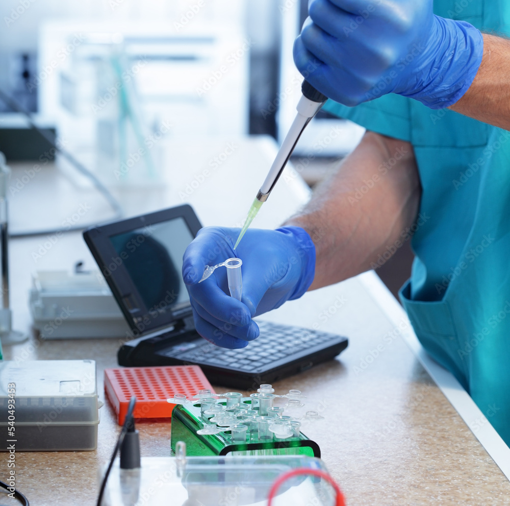 scientist with test tubes and flasks conducting an experiment in a ...