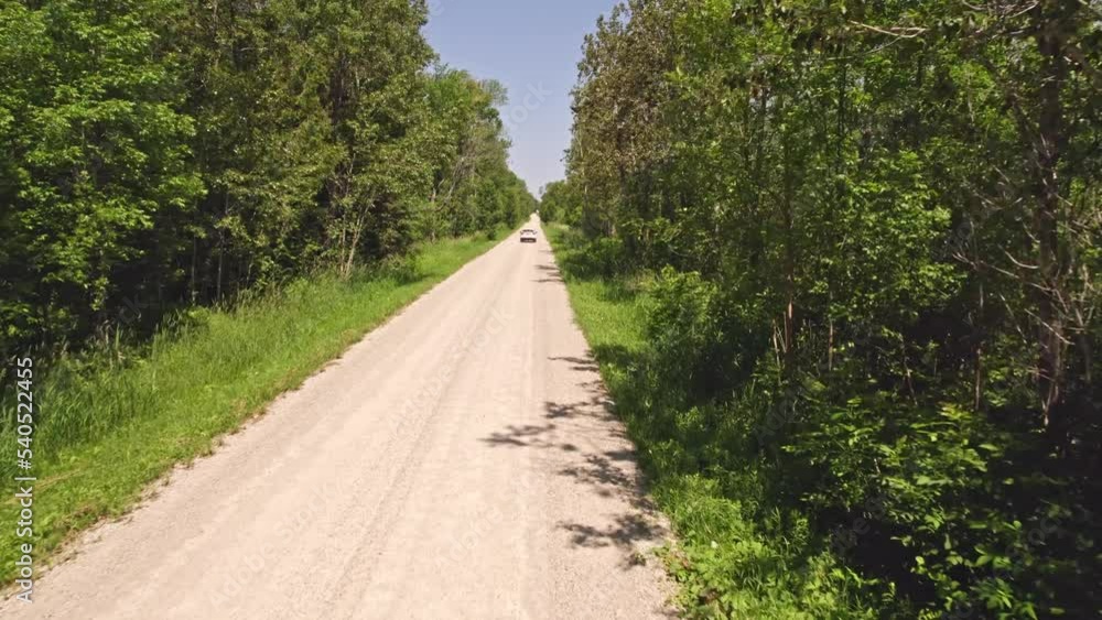 Aerial view of road in American summer forest. Straight out of country ...