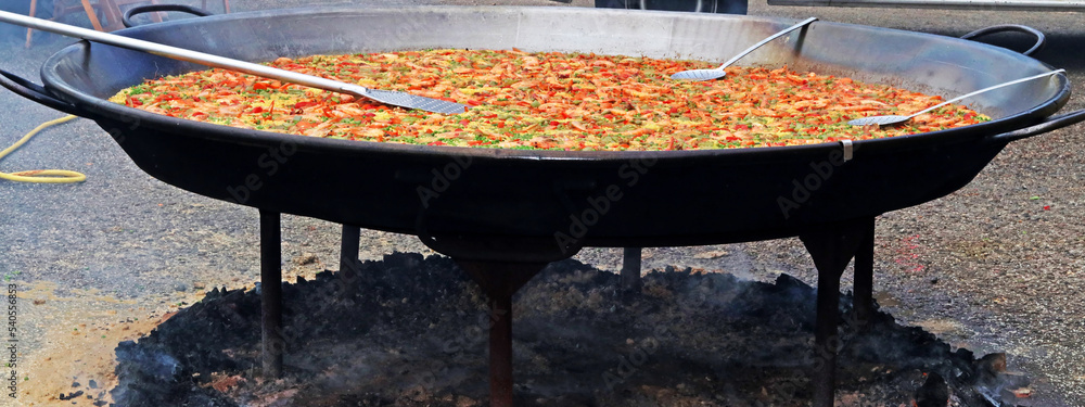 Preparation of a giant paella, a typical dish of Spanish cuisine, with ...