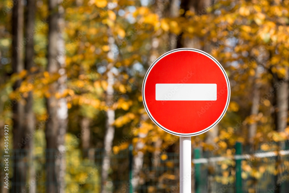 Red road sign "Entry prohibited" on the background of yellow autumn ...