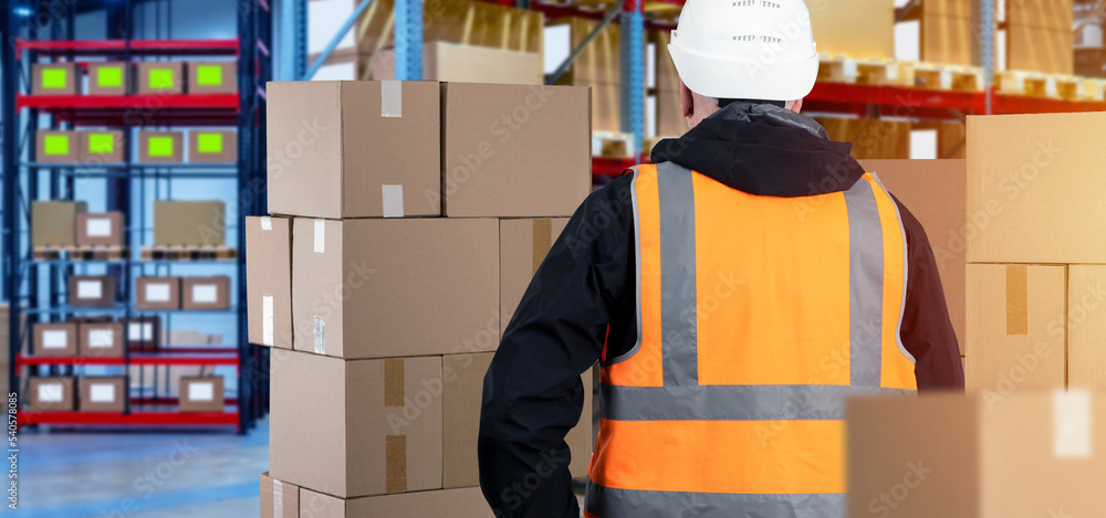 Storekeeper among boxes. Man standing in warehouse with his back to ...