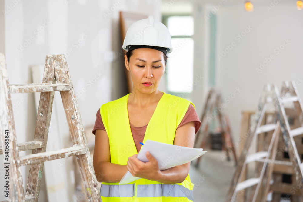 Female asian engineer matching check list during repair works in house ...