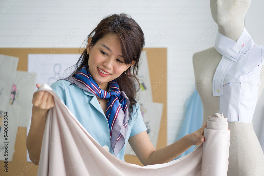 Fashion designer room. Young asian dressmaker in striped scarf check ...