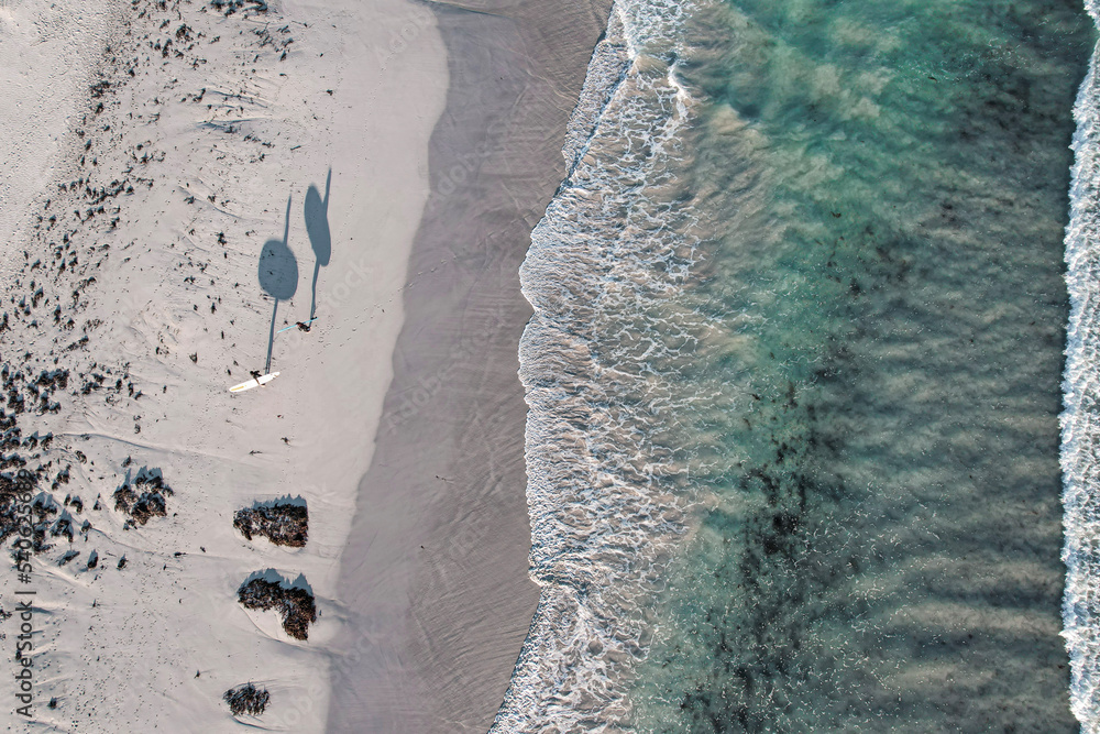 Two surfers going out of the water after a surf session. Shadow of ...