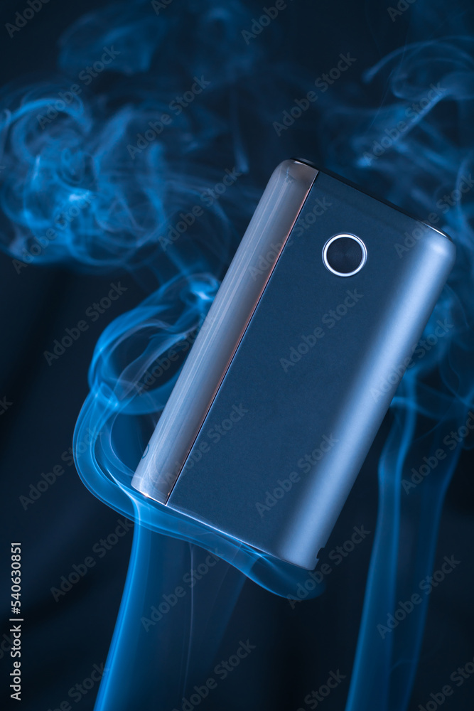 Black new GLO heating smoking device floats in puffs of white blue neon ...
