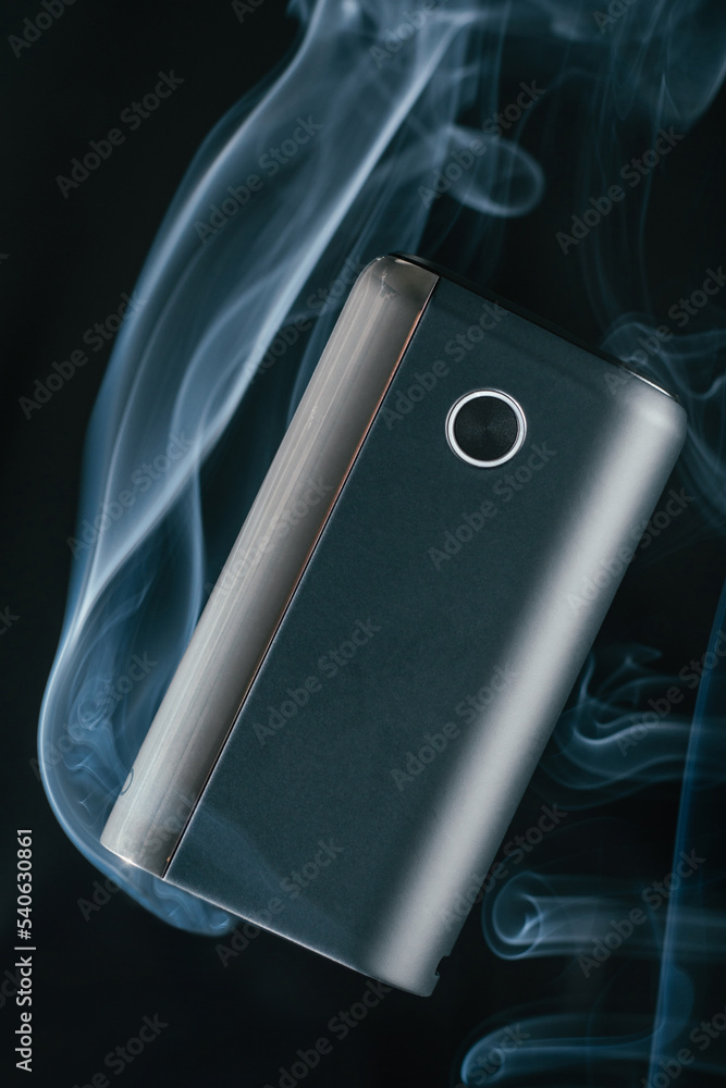 Black new GLO heating smoking device floats in puffs of white blue neon ...