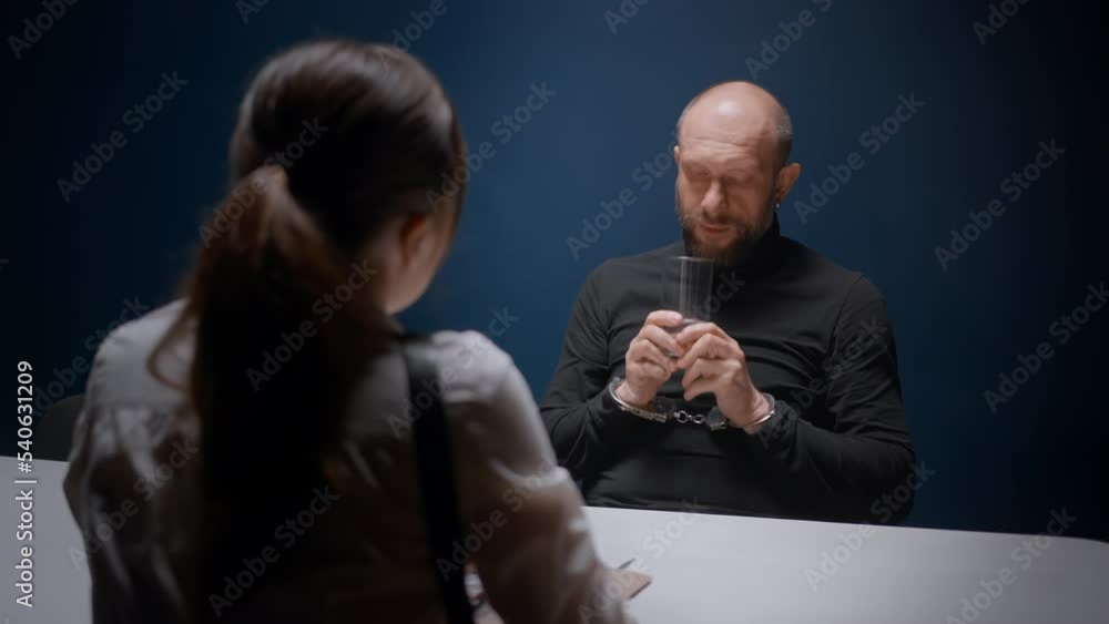 Detective cop brings and gives detained murder glass of water. Arrested ...