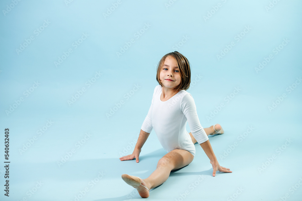 8yo girl in a white leotard doing splits, looking at the camera. Stock ...