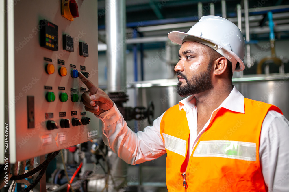 Asian engineer worker wearing safety uniform control operating machine ...