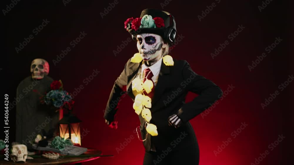 Scary woman with costume of death dancing in studio, listening to music ...