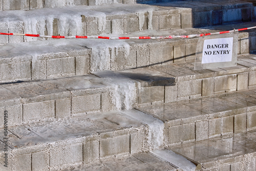 Stairs covered with ice and caution sign Danger, no entry. Ice covered ...