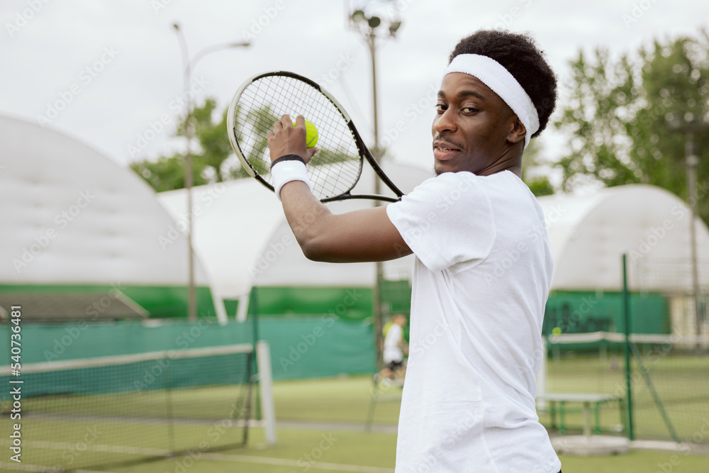 Famous tennis player of African appearance trains on tennis court and ...
