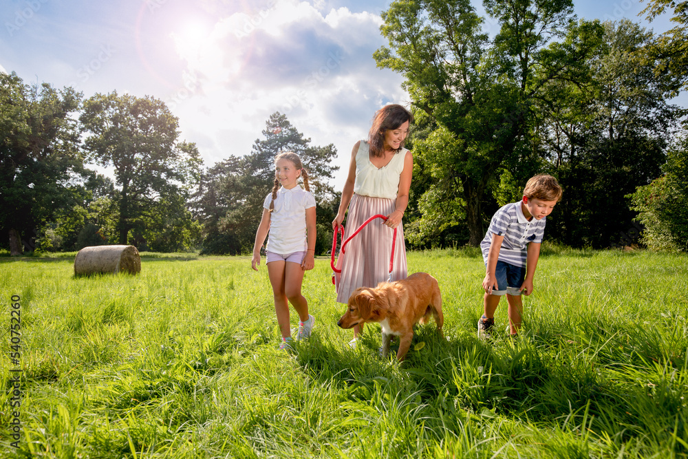Mom with happy children and their dog walking outdoor Stock Photo ...