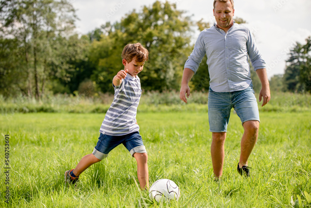 Father and daughter watching bugs in the grass using magnifying glass ...