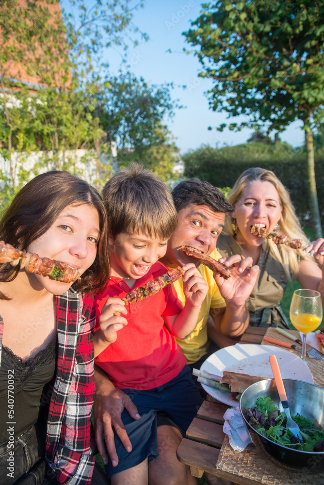 Foto de Hungry family sitting around table. Mid adult parents and ...