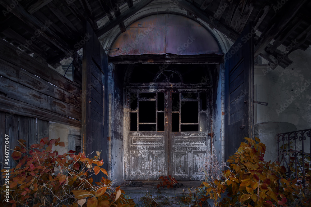 Porch of an old haunted house at dusk. Door to an worn-down abandoned ...