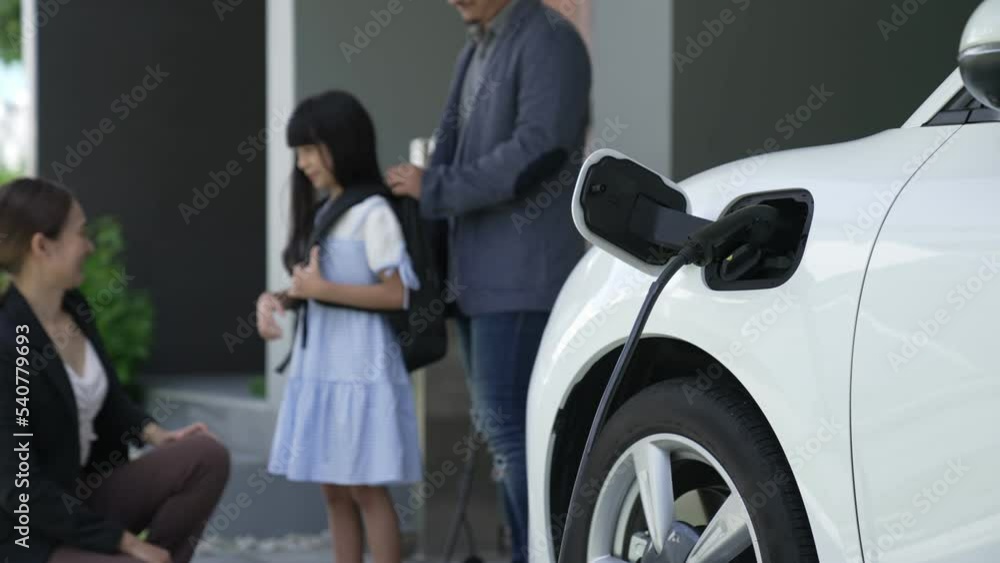 Progressive parents with electric vehicle and home charging station ...