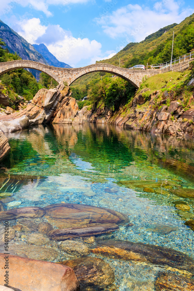 Ancient double arch stone Roman bridge (Ponte dei Salti) over the clear ...