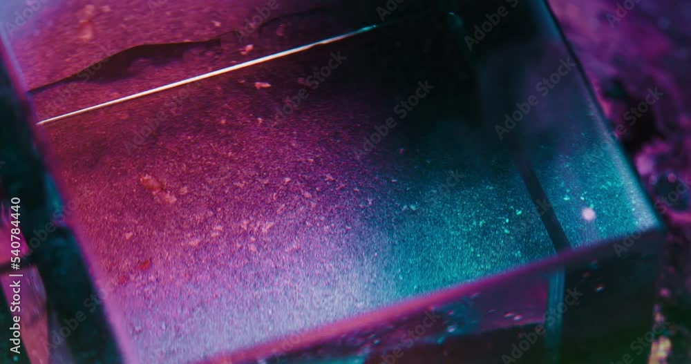 Glass cube rotation. Fluorescent color background. Defocused neon pink ...