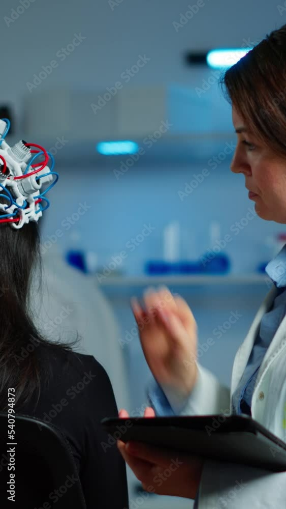 Vertical video: Woman patient wearing performant eeg headset scanning ...