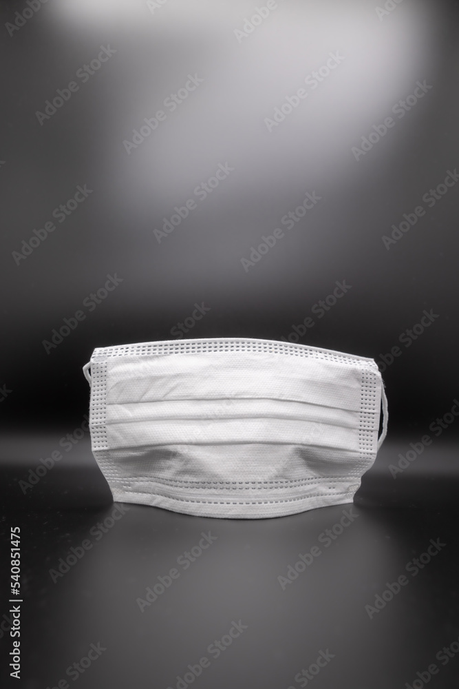 white disposable mask in corona times with black background free text ...