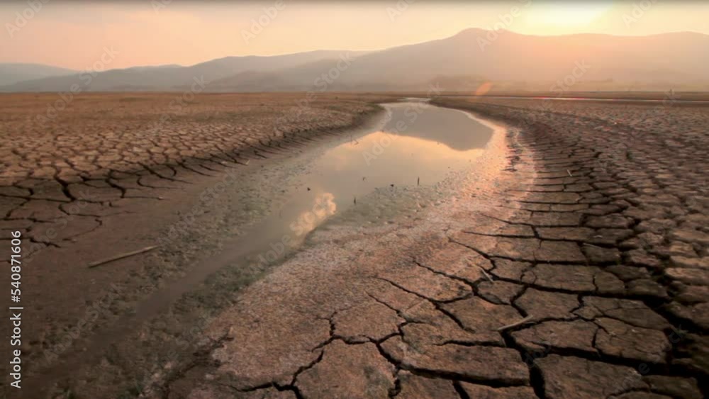Landscape of river drying with dry cracked earth at sunset metaphor ...