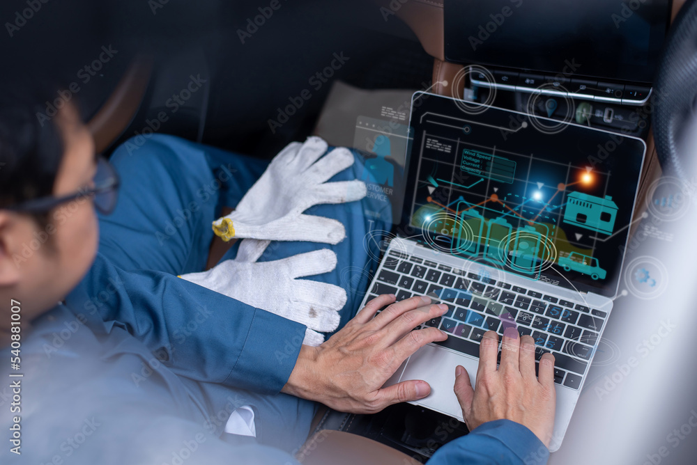 A technician examines the vehicle's data while using a computer ...