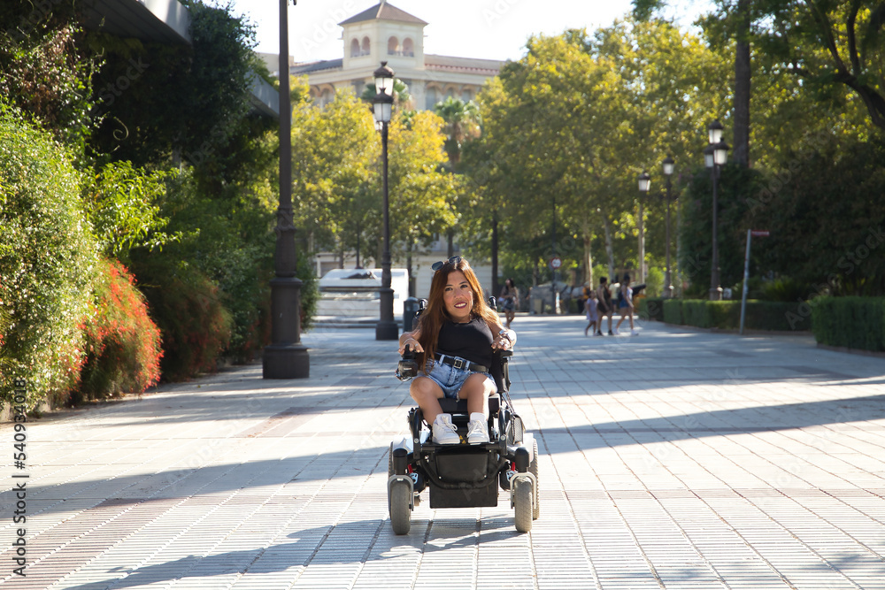 Disabled woman with reduced mobility and small stature in an electric ...