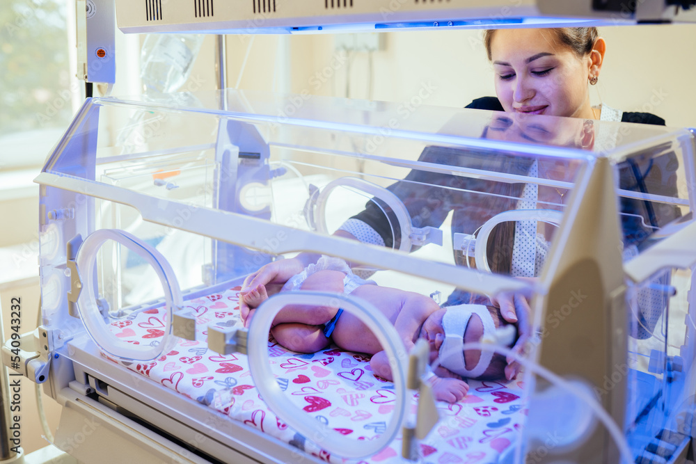 Mother caring her little daughter while new born baby lying at ...