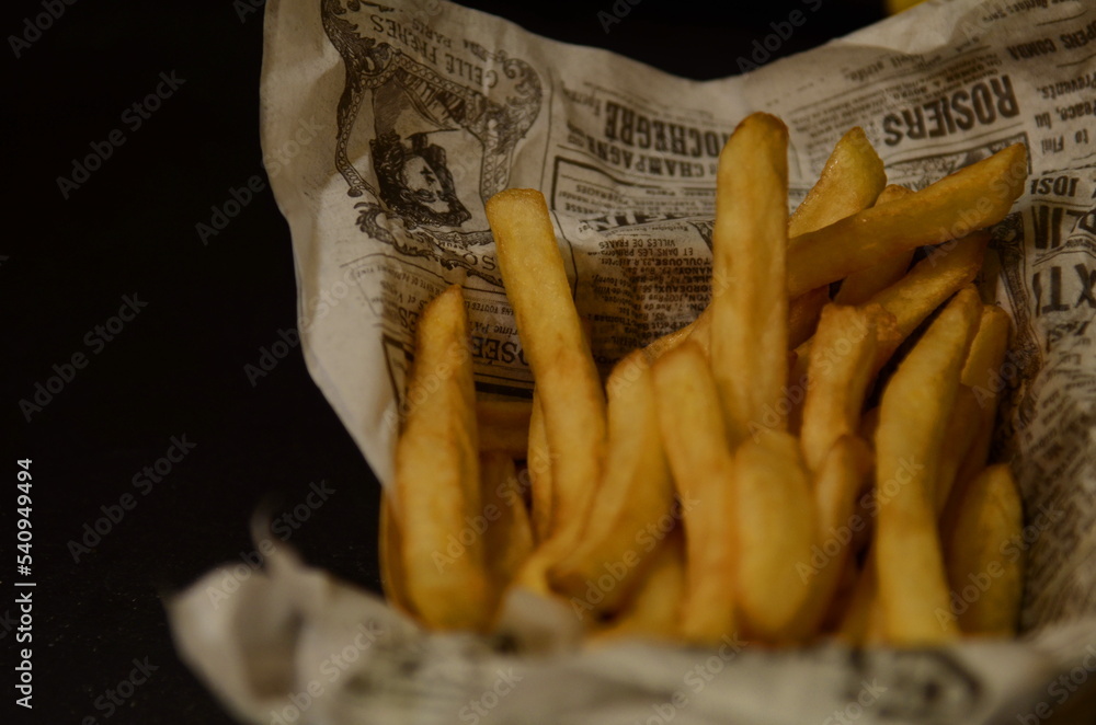 French fries close up. Belgian potatoes in vintage newspaper ...