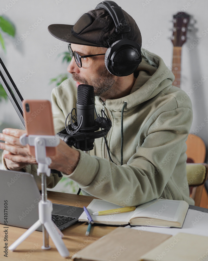 man records a podcast or audio content in a home office. a successful ...