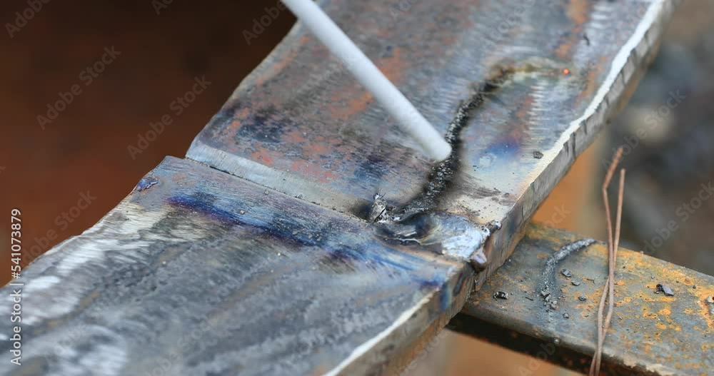 Welder, a person who welds parts of a metal part together. Close-up of ...