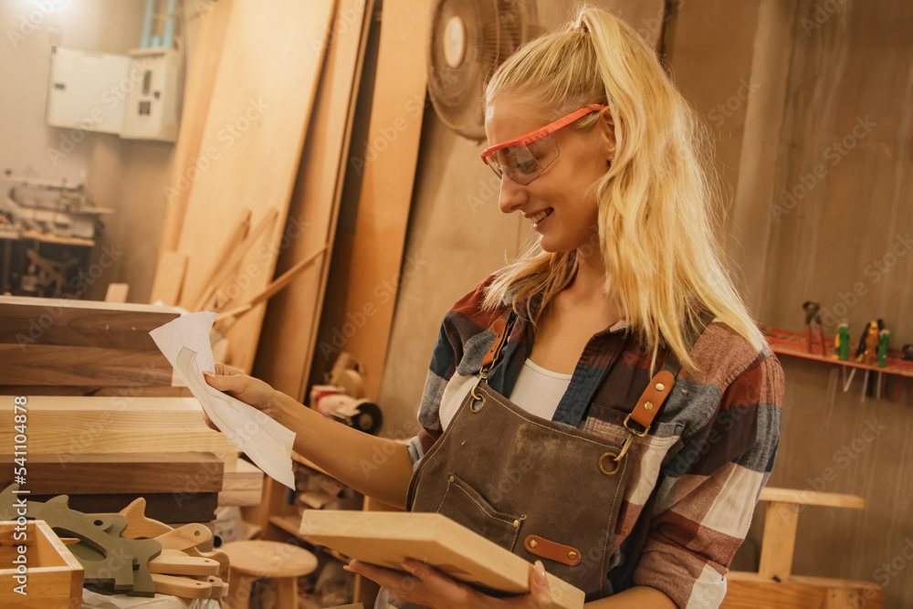 Side view portrait female carpenter wearing safety glasses looks at the ...