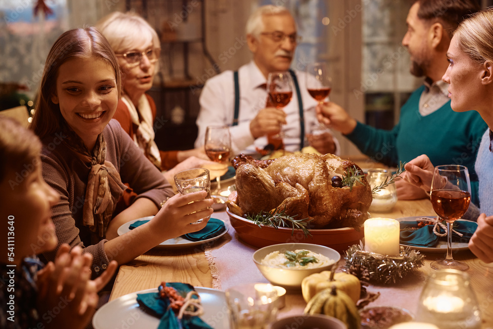 Happy teenage girl and her family enjoying in conversation during ...