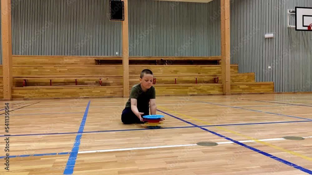 Boy with autism and sensory disorders sitting on gymnasium floor and ...