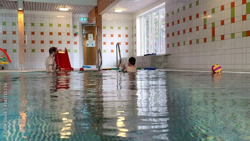 8 year old boy with autism is getting used to water in swimming pool ...