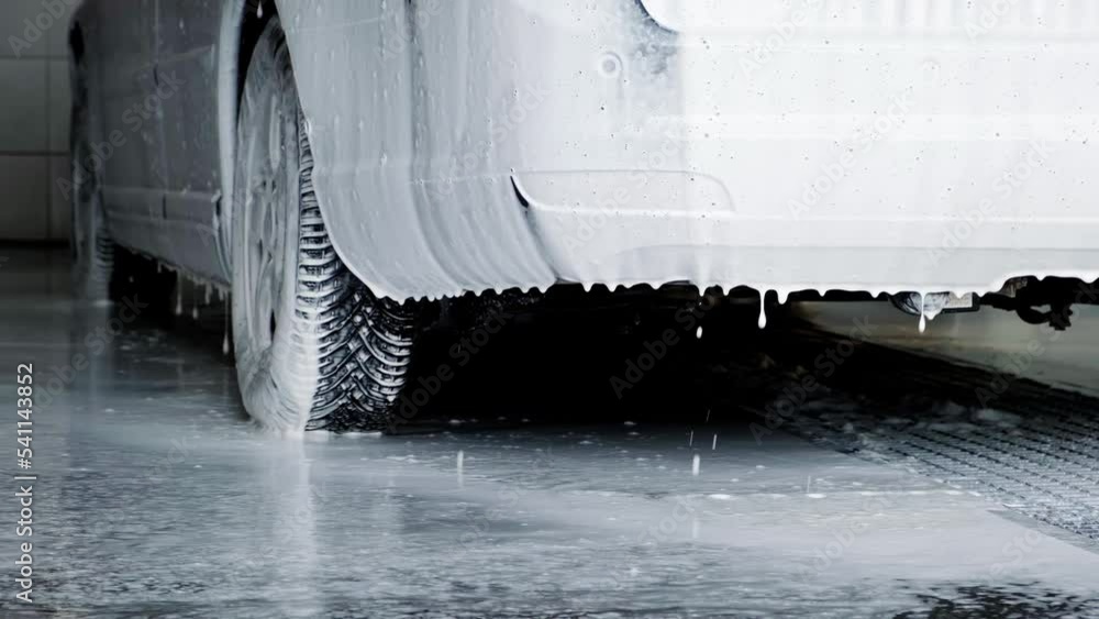 Self service car wash. Car wheels in soap foam close-up. Professional ...