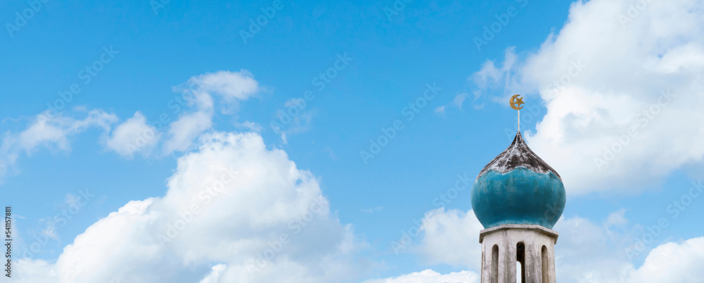Crescent moon and star at a top of Old Mosque over the clouds on blue ...