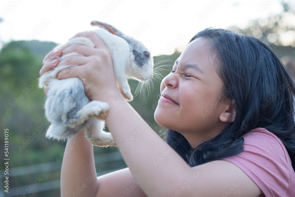 teenage girl with the rabbit. happy little girl holding cute fluffy ...