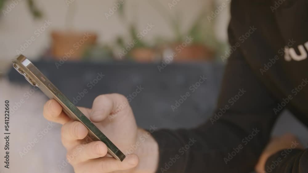 Side angle of a man scrolling and swiping and typing on an Iphone with ...