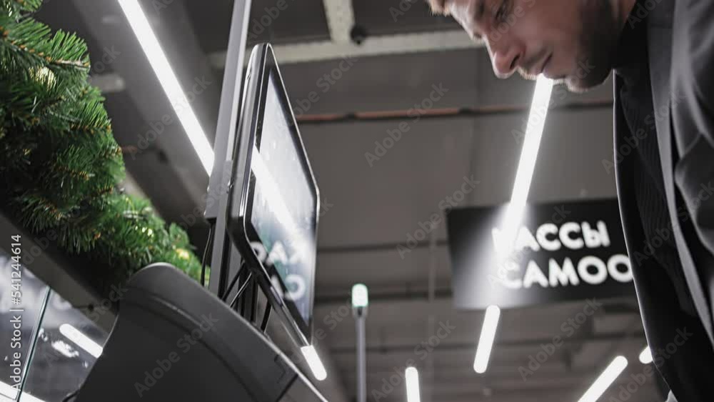 Buyer scans product through barcode scanner at self-service checkout ...