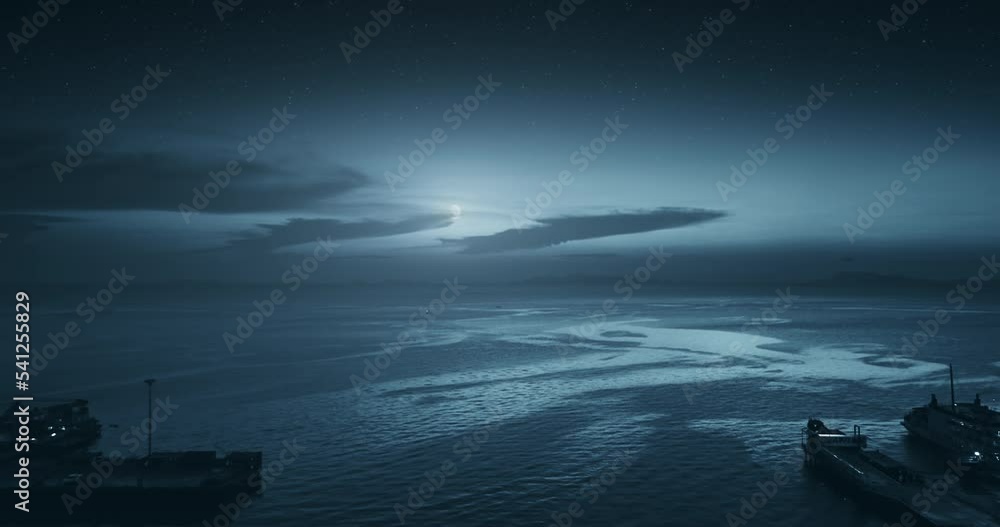 Aerial view of moon light night sea. Fishing boat port on starry sky ...