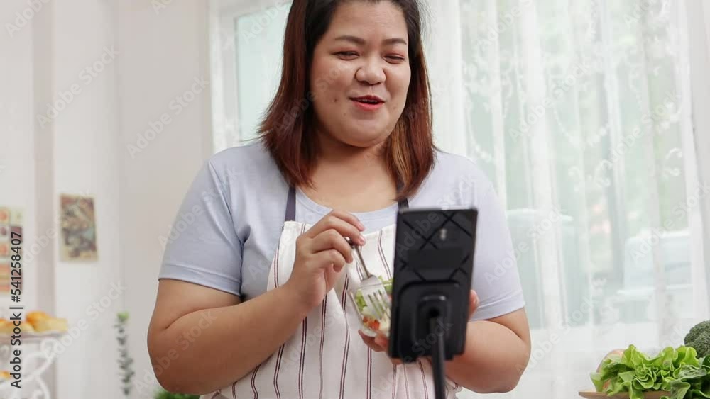 Fat Asian woman cooks organic food in her kitchen at home. Record ...