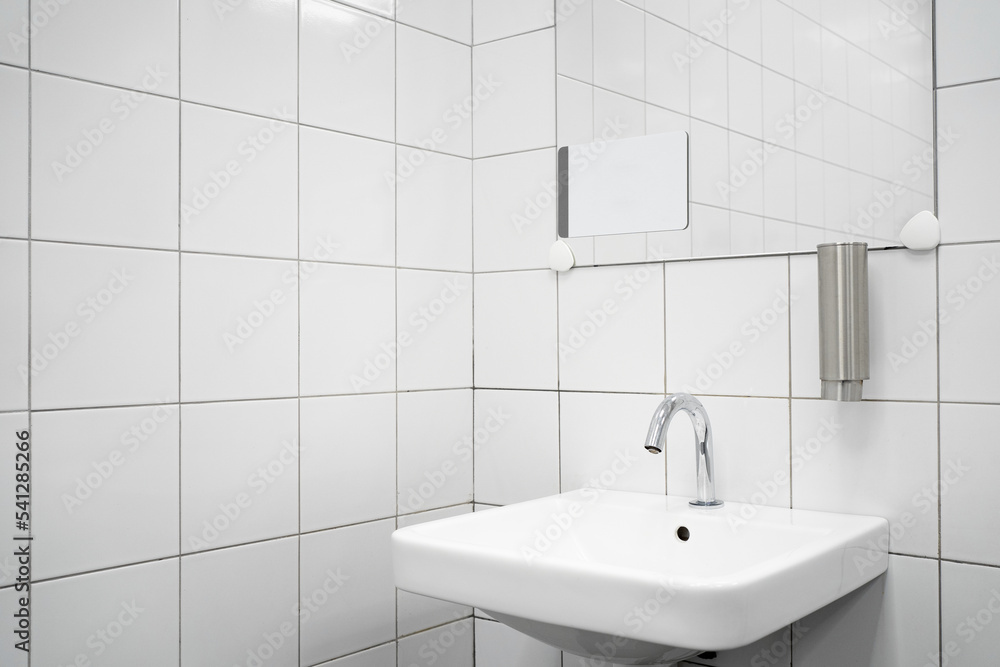 Toilet hand wash area with white colour ceramic tiles. White colour ...