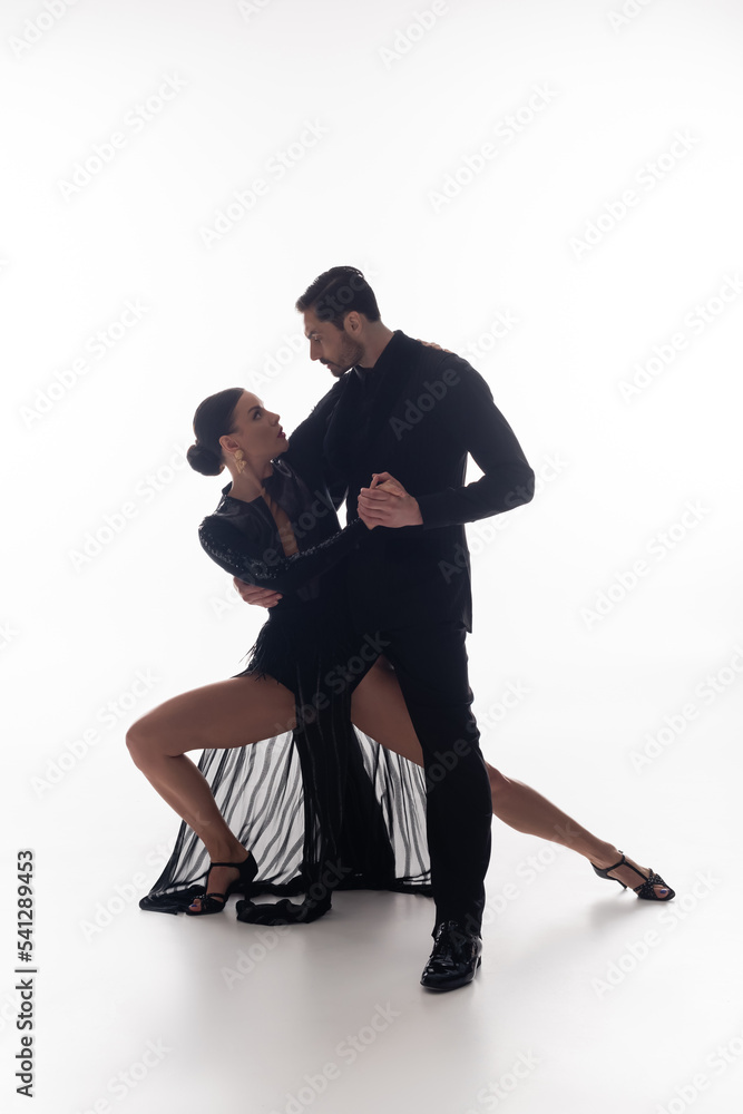 Side view of professional dancers holding hands while performing tango ...