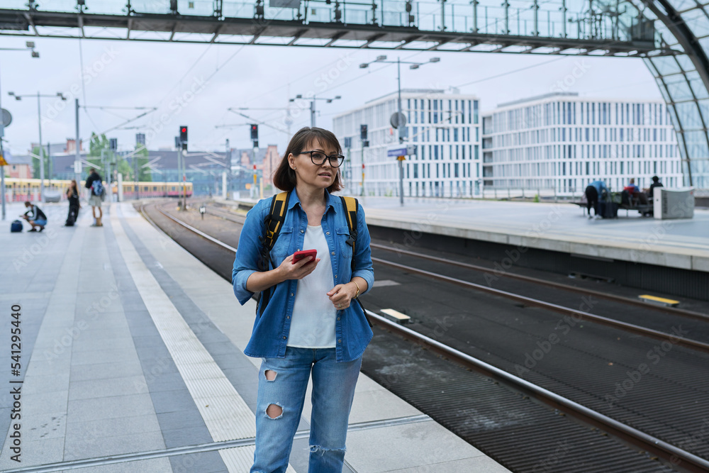 Woman waiting for railway public electric transport on platform of city ...